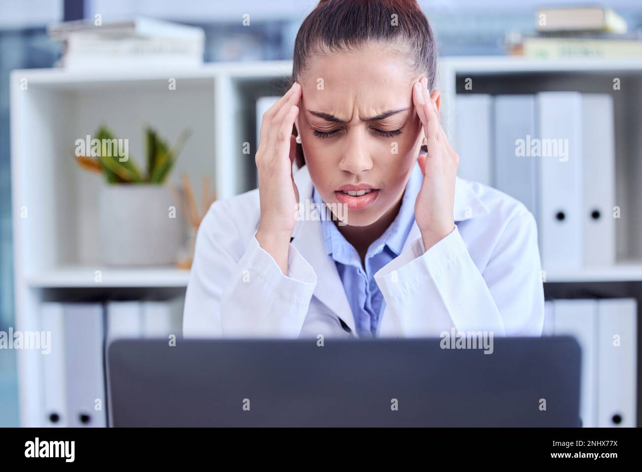 Burnout, stress and doctor with a headache from a laptop, healthcare ...