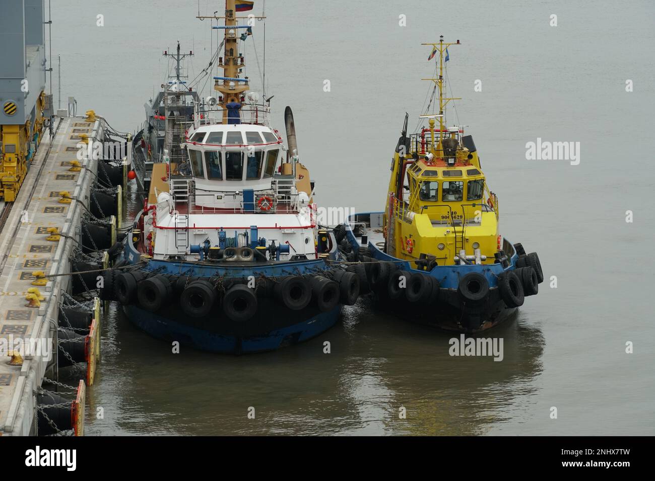 Two tugboats with blue hull and white and yellow superstructure moored ...
