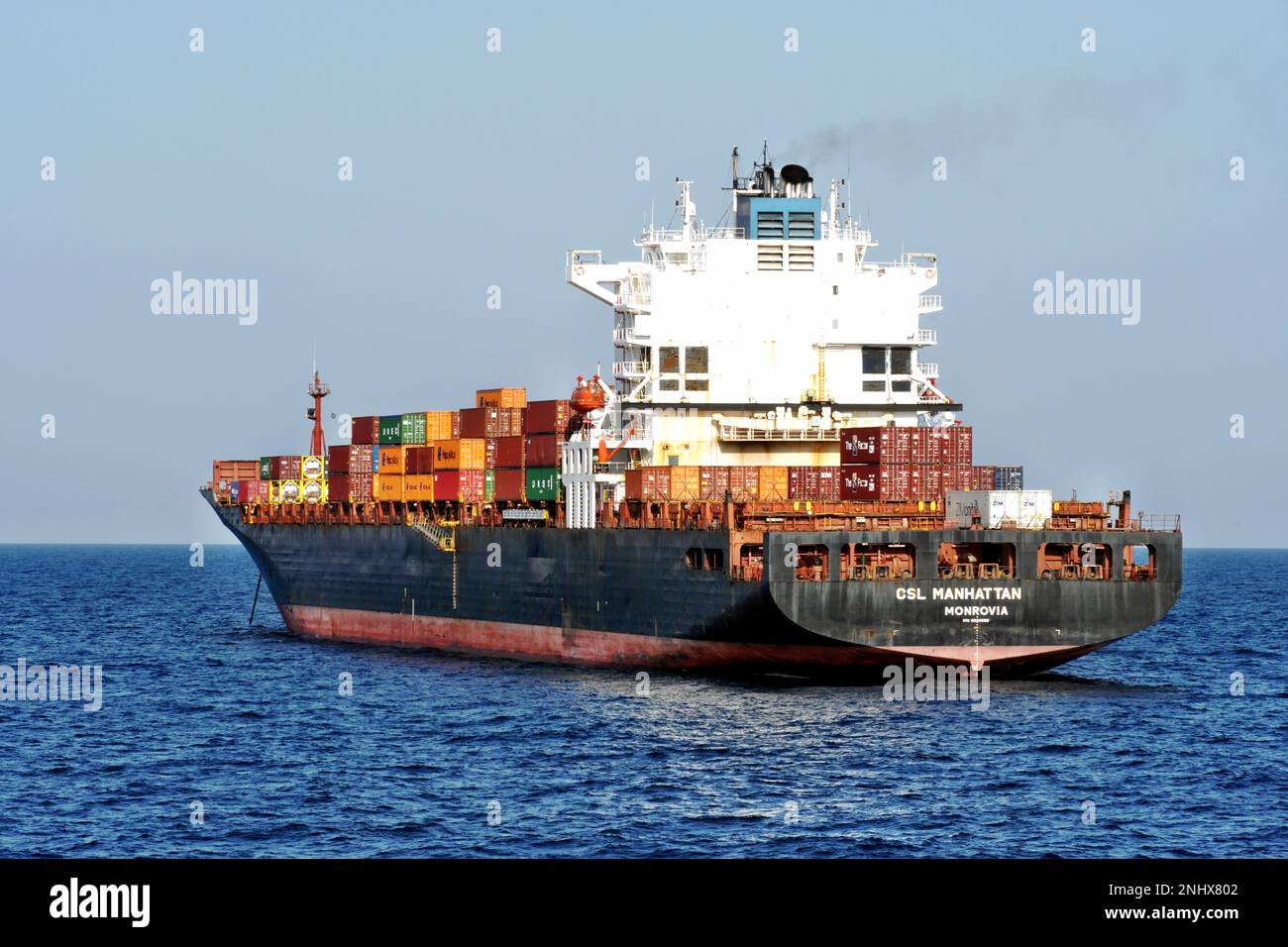 Loaded container vessel with black hull and white superstructure viewed ...