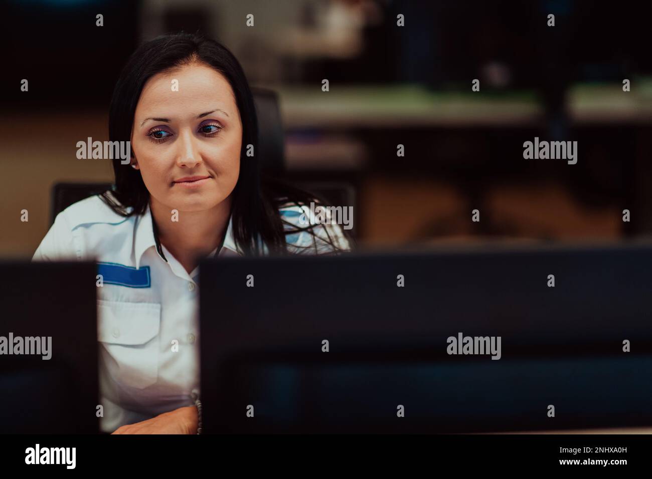 Female security operator working in a data system control room offices ...