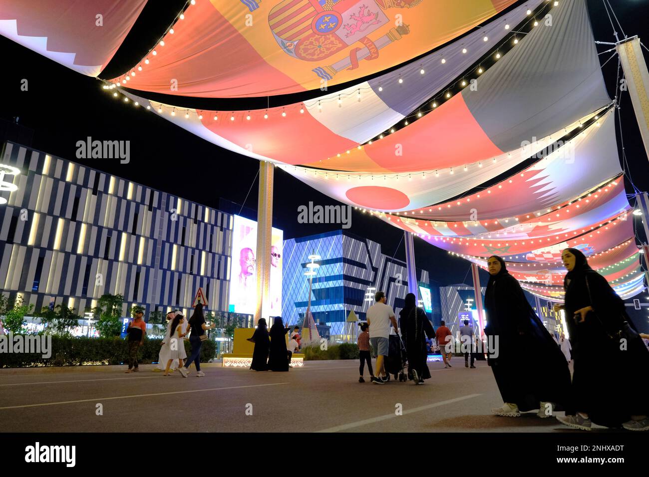 People walk under big pennants of the flags of the participating ...