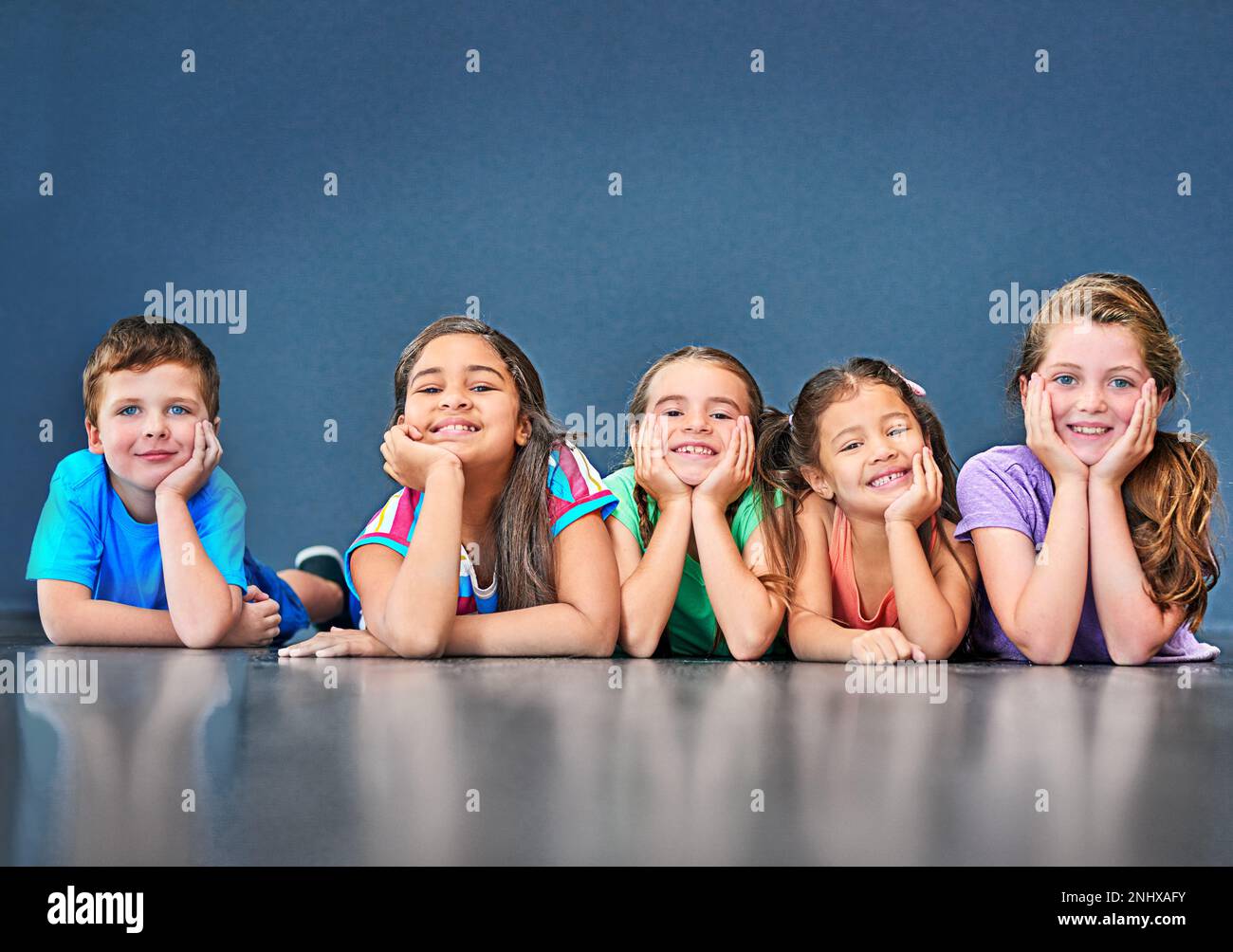 Just us kids. Studio shot of a diverse group of kids lying together on ...