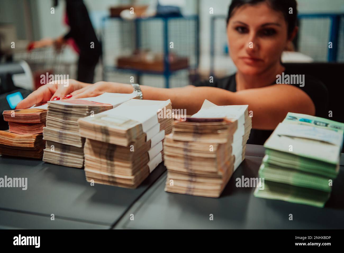 Bank employees using money counting machine while sorting and counting ...