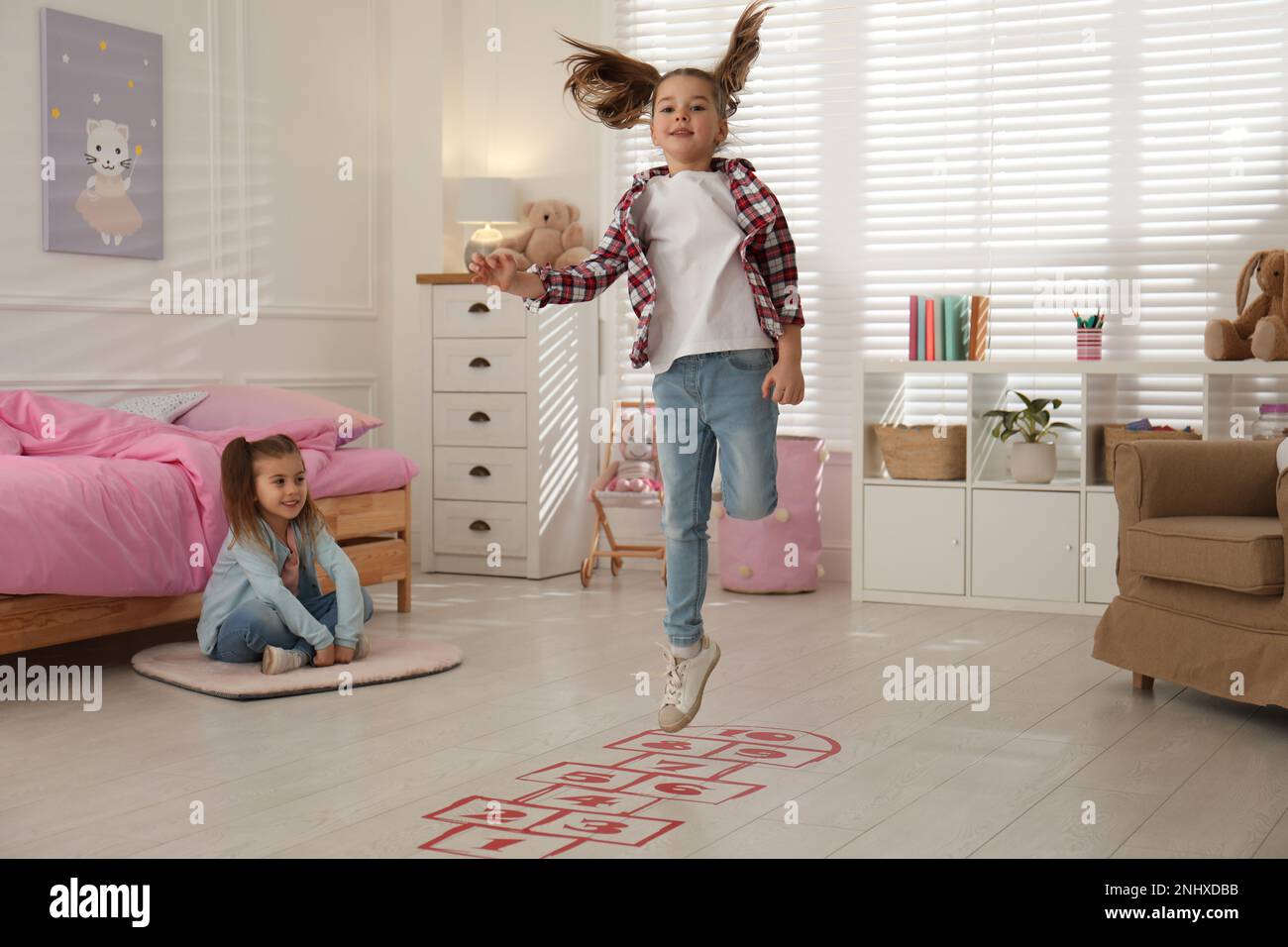 Cute little girls playing hopscotch at home Stock Photo - Alamy