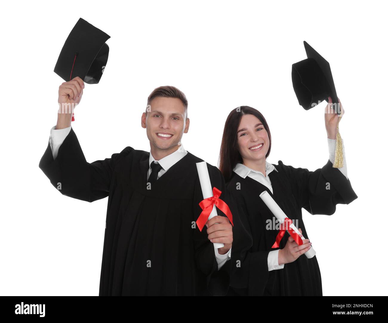 Happy students in academic dresses with diplomas on white background ...