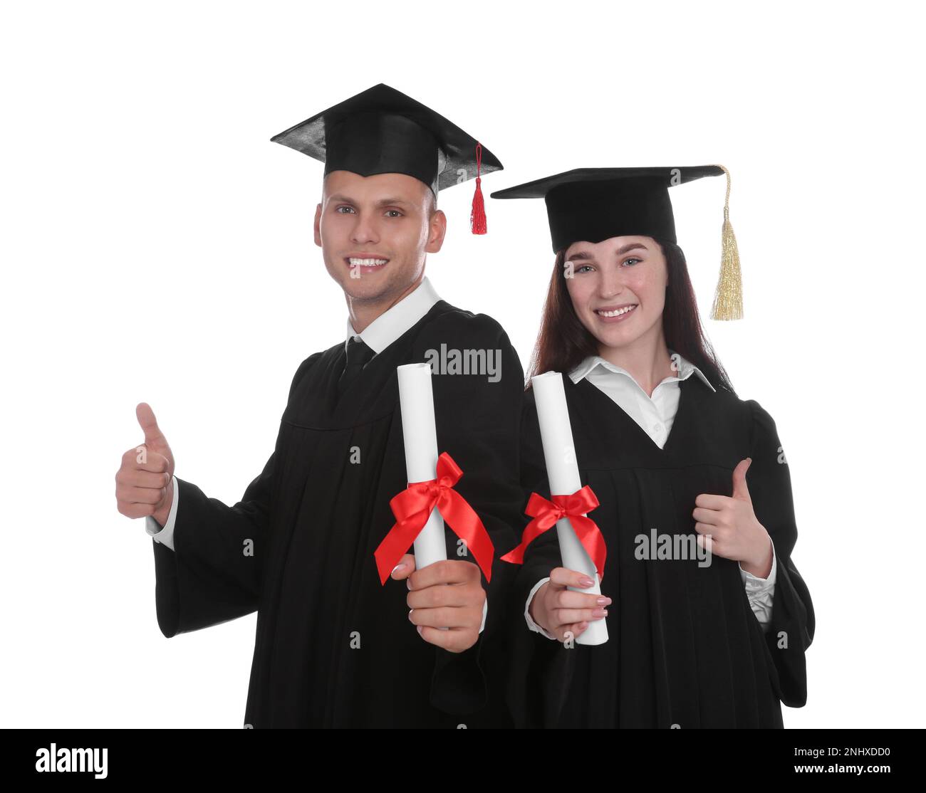 Happy students in academic dresses with diplomas on white background ...