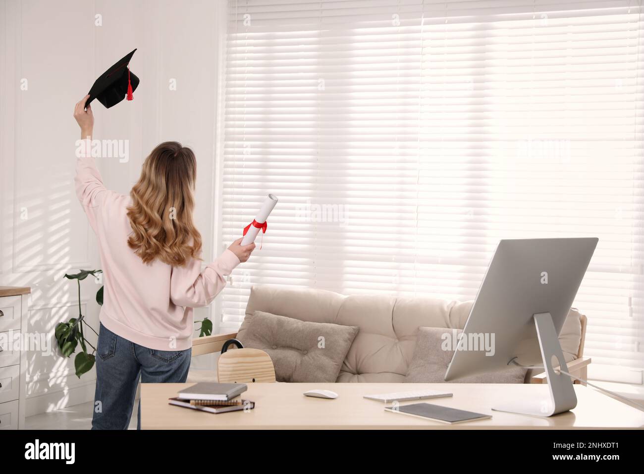 Happy student with graduation hat and diploma at workplace in office ...