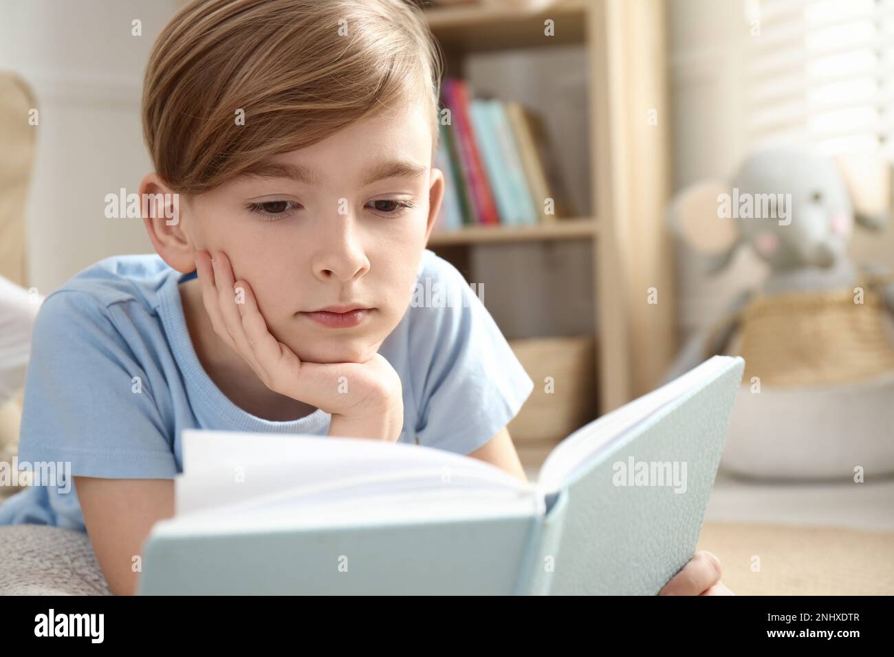 Little boy reading book on floor at home Stock Photo - Alamy