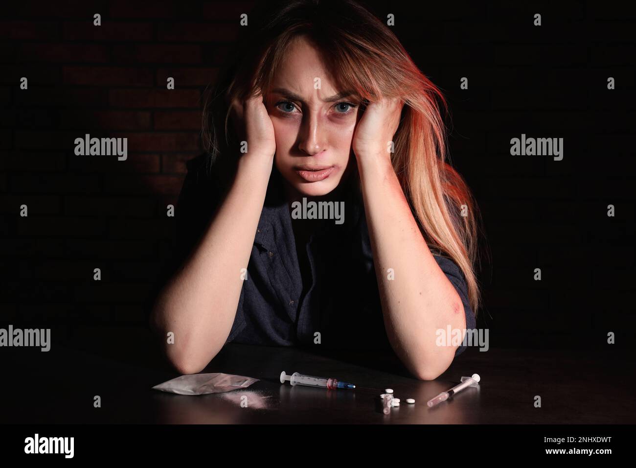 Addicted woman at table with different drugs on black background Stock ...