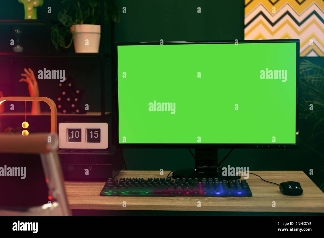 Modern computer and RGB keyboard on wooden table indoors. Mockup green ...