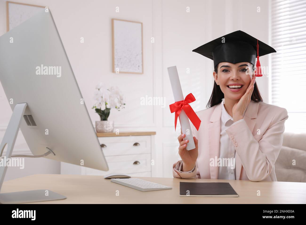 Happy student with graduation hat and diploma at workplace in office ...