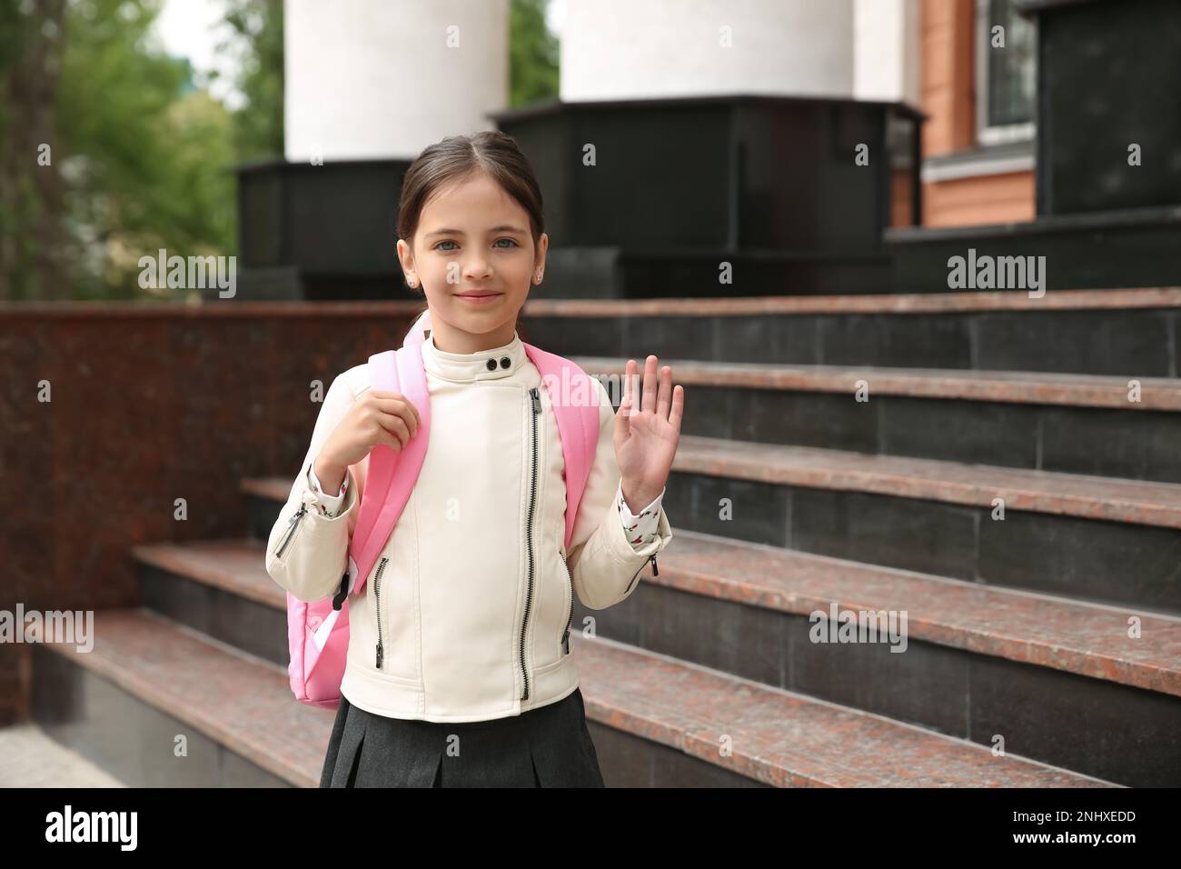 Little girl waving near school entrance outdoors Stock Photo - Alamy