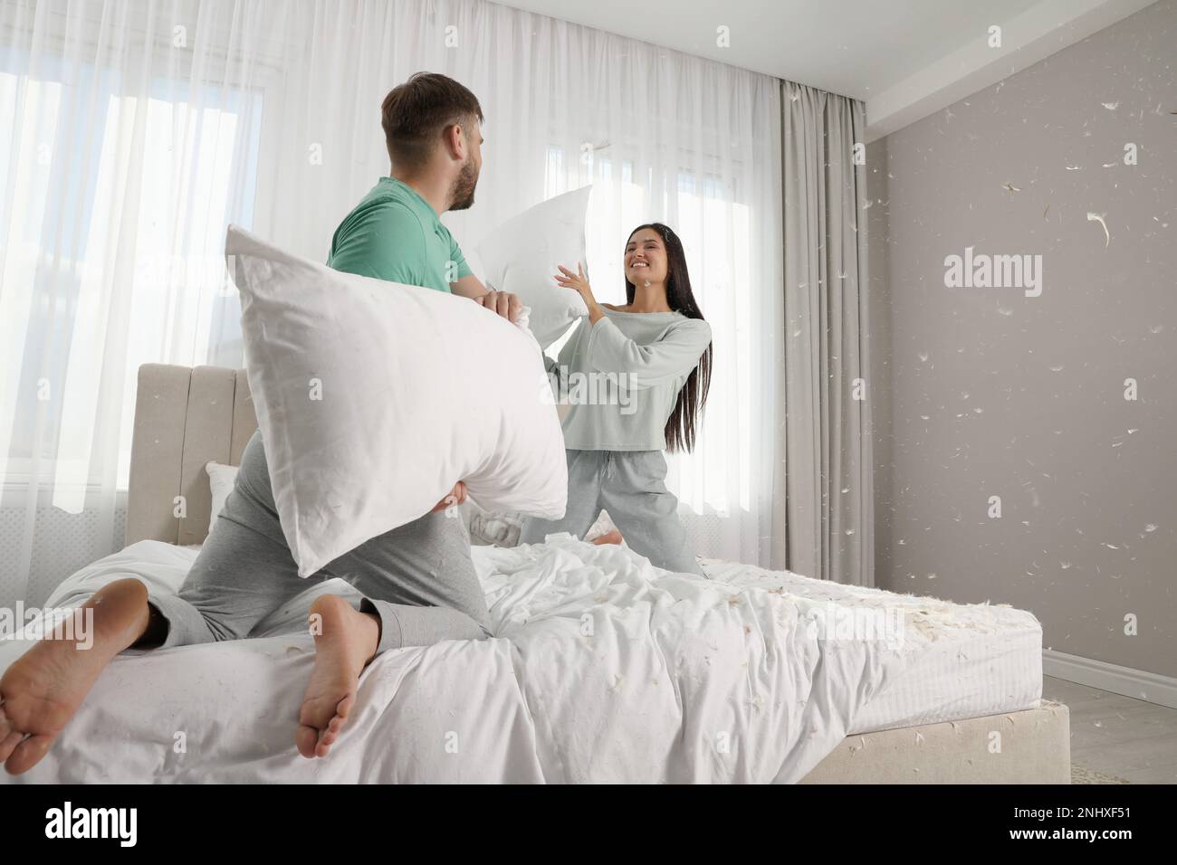 Happy young couple having fun pillow fight in bedroom Stock Photo - Alamy