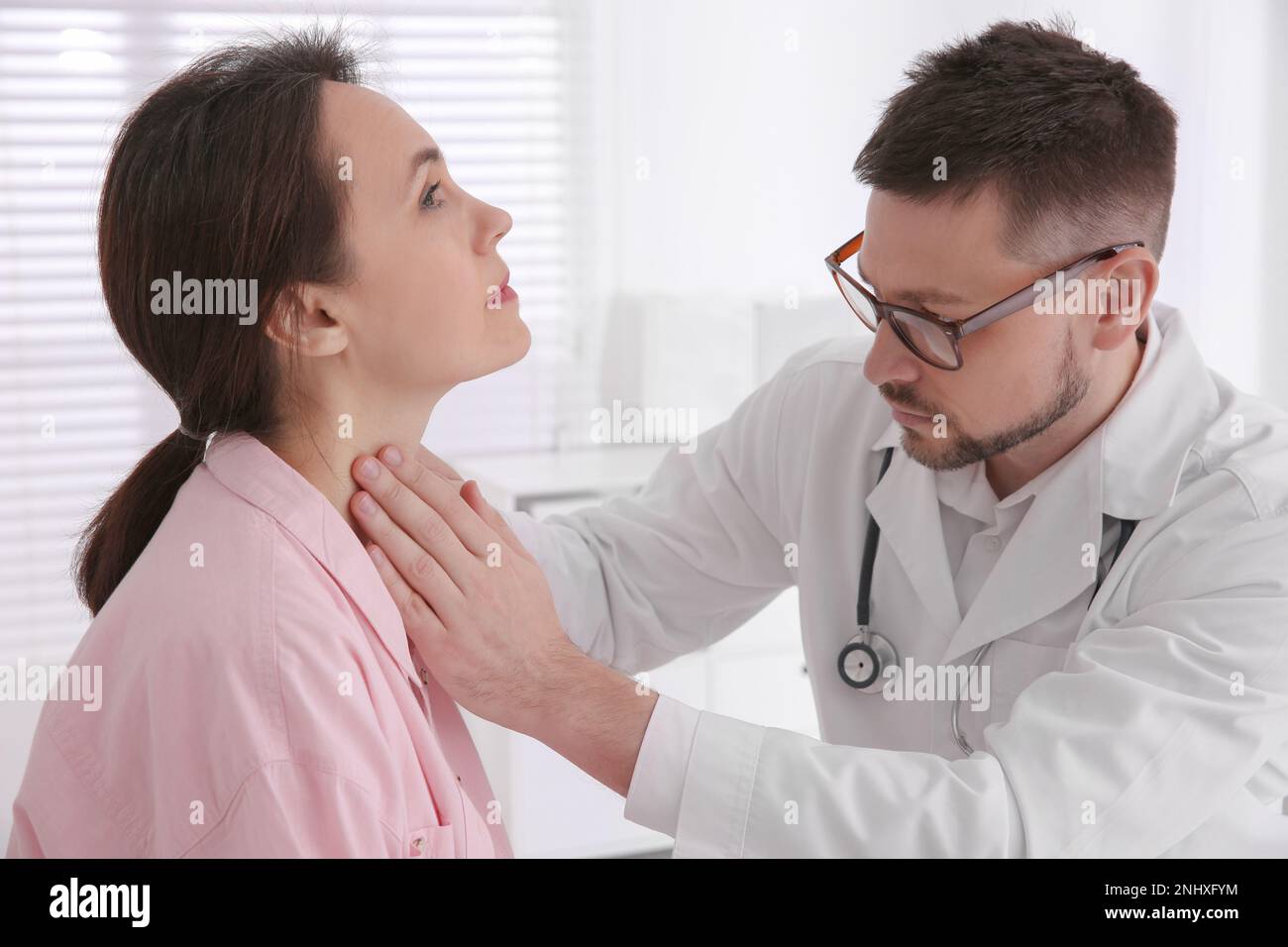 Doctor examining thyroid gland of patient in hospital Stock Photo - Alamy