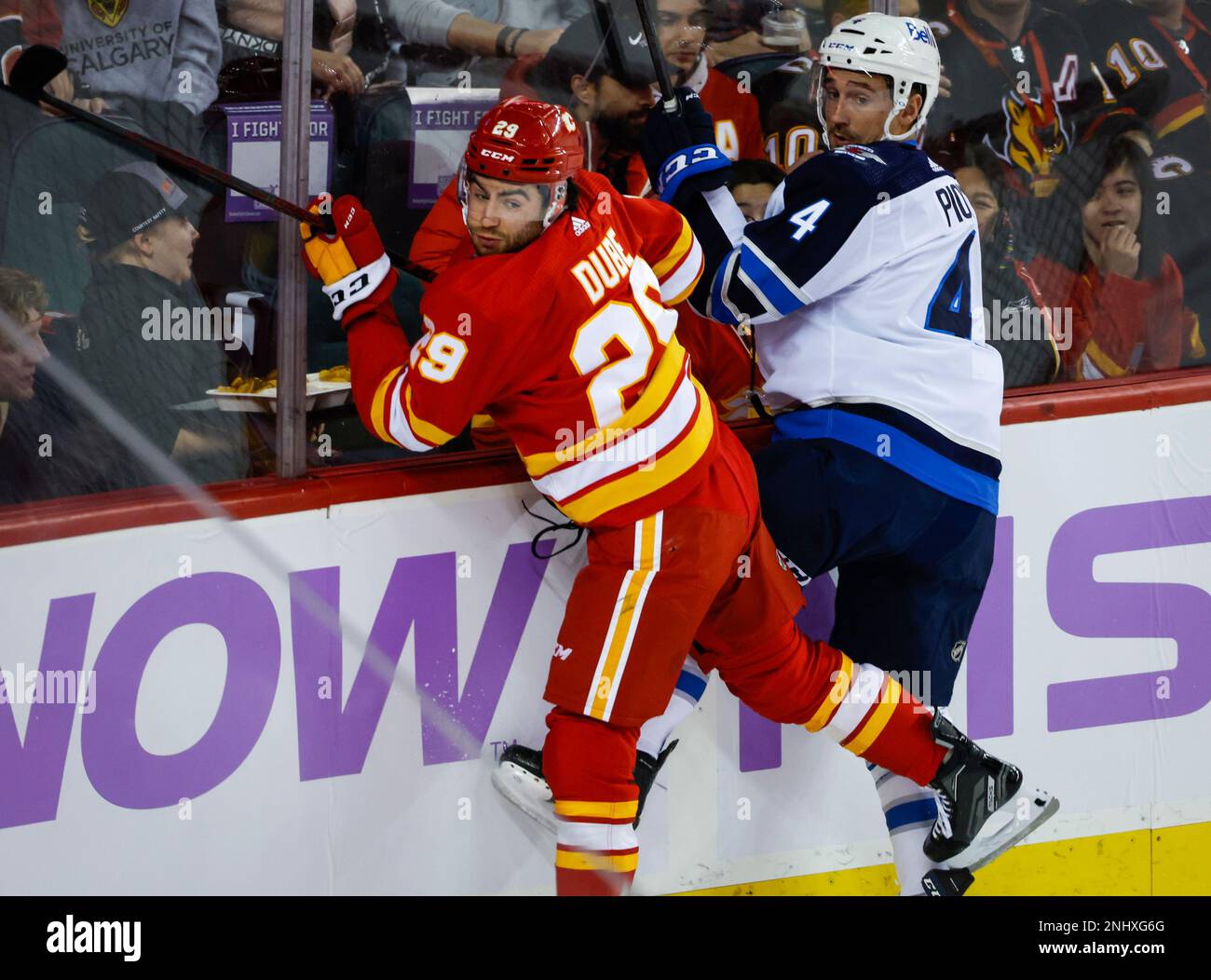 Winnipeg Jets defenseman Neal Pionk, right, is checked by Calgary ...