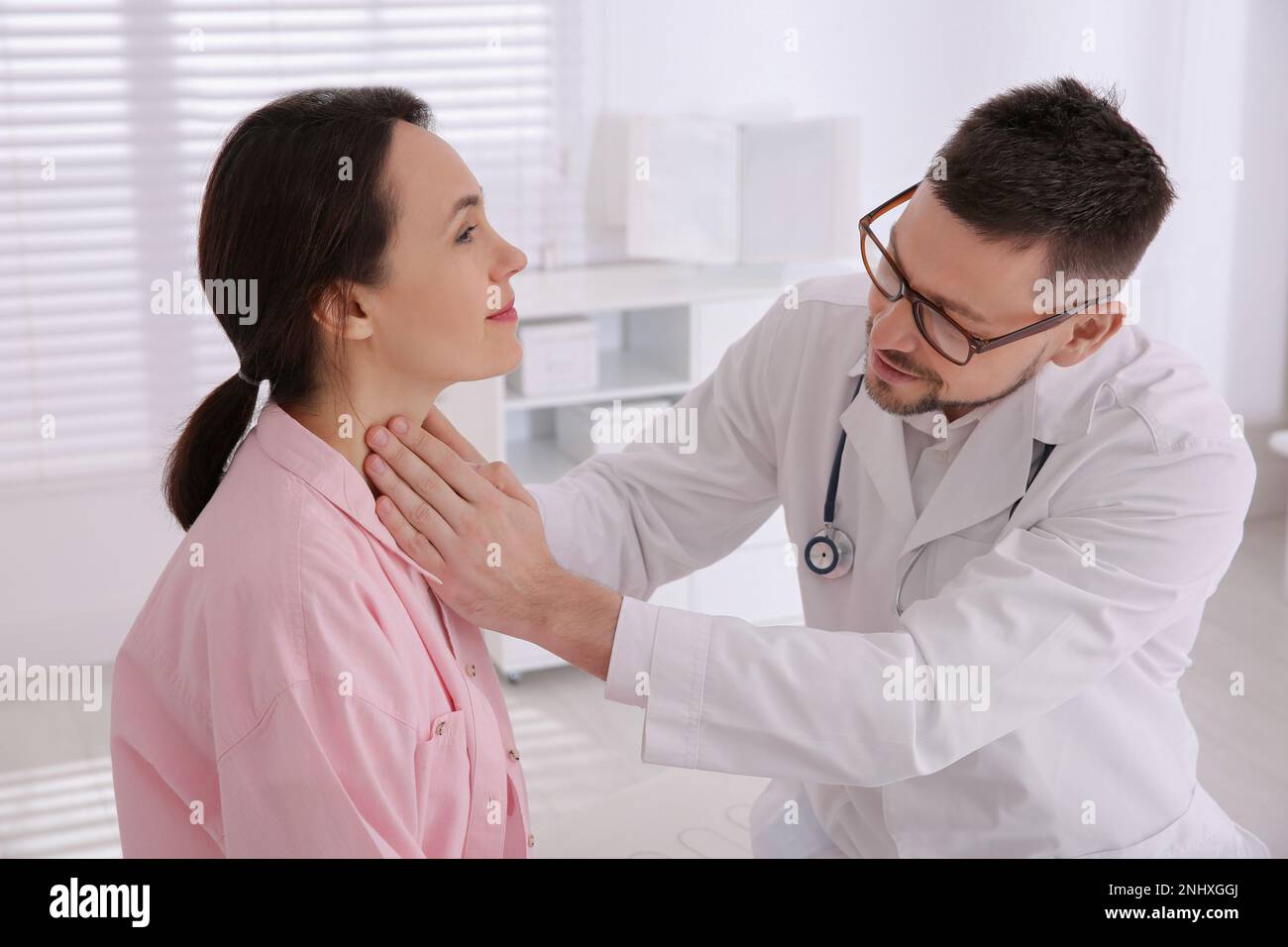 Doctor examining thyroid gland of patient in hospital Stock Photo - Alamy