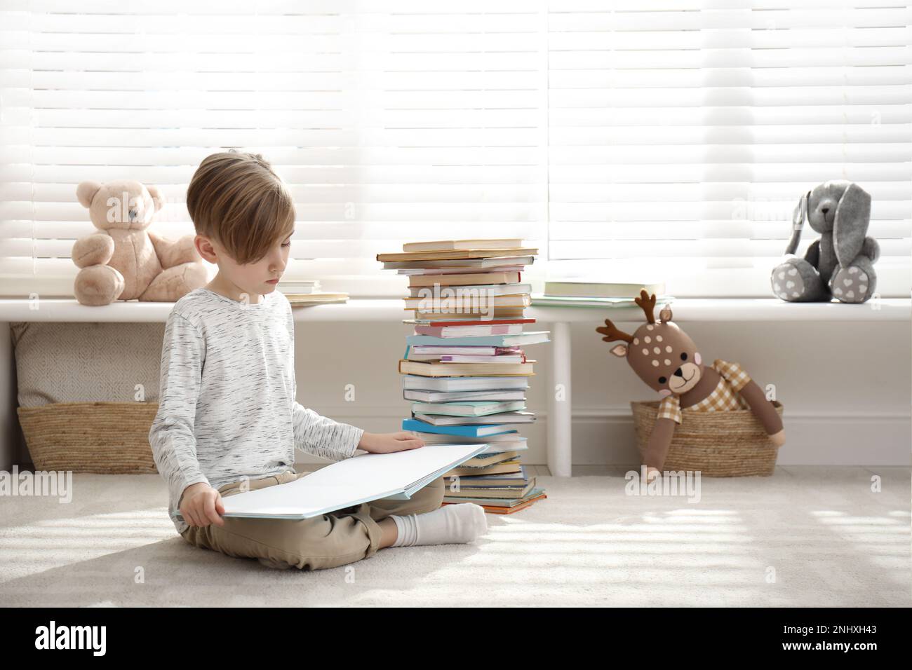 Little boy reading book on floor at home Stock Photo - Alamy