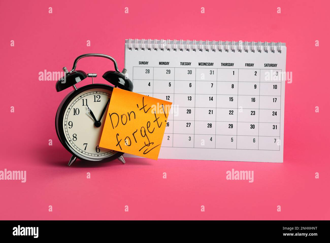 Alarm clock, calendar and reminder note with phrase Don't forget on ...