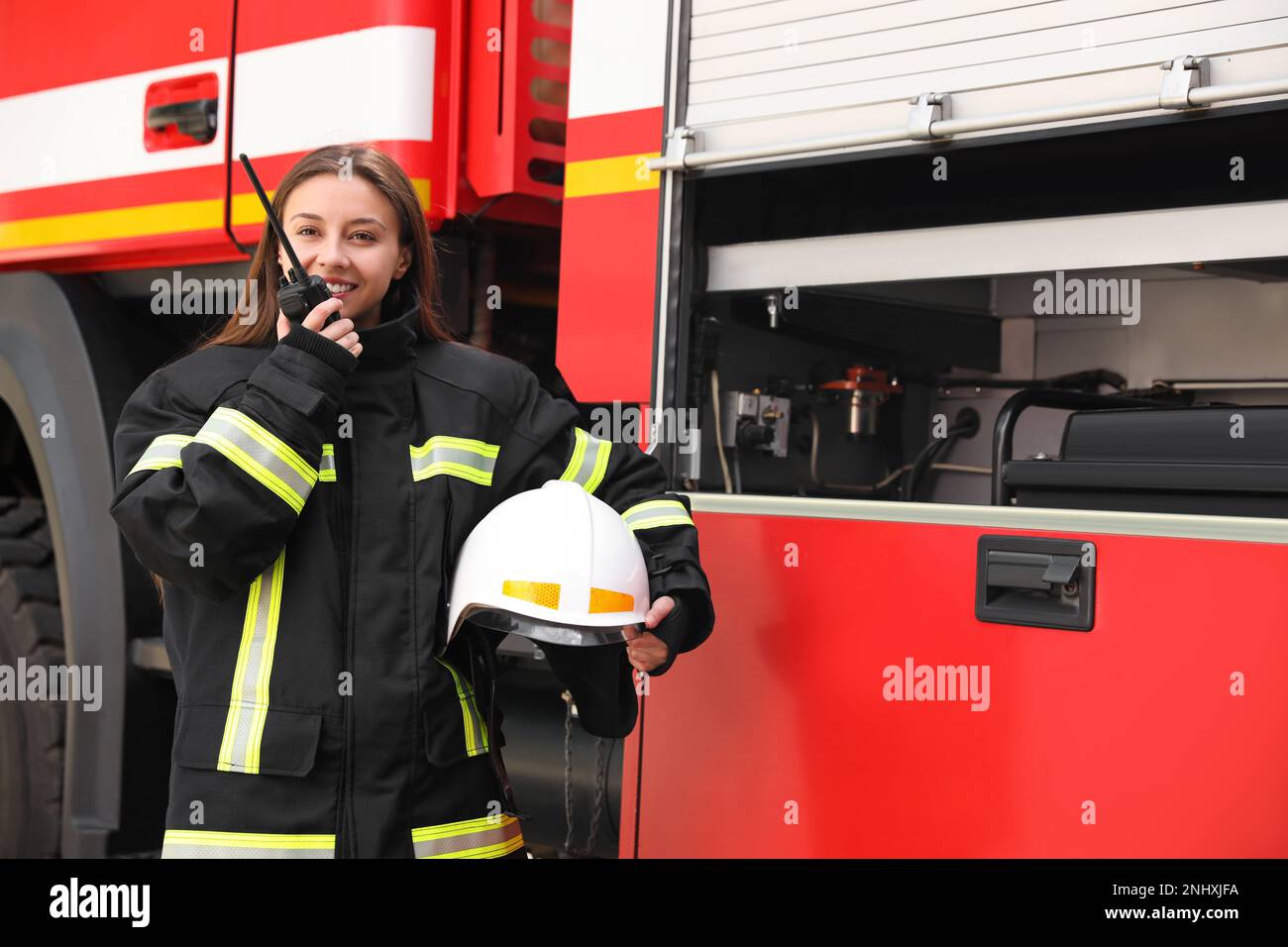 Firefighter in uniform using portable radio set near fire truck Stock ...