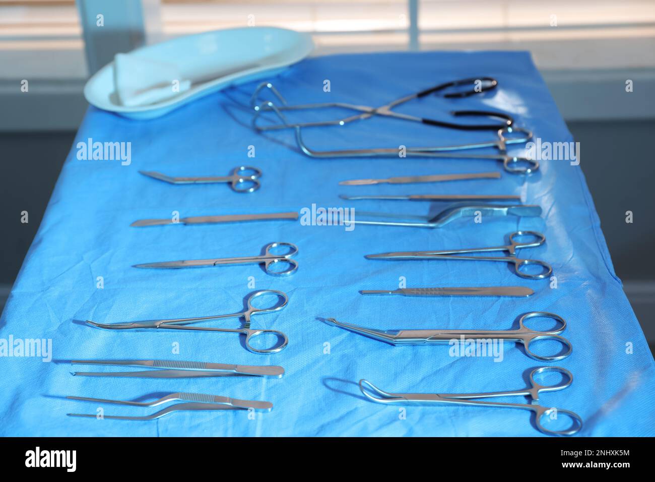 Different surgical instruments on blue table indoors Stock Photo - Alamy