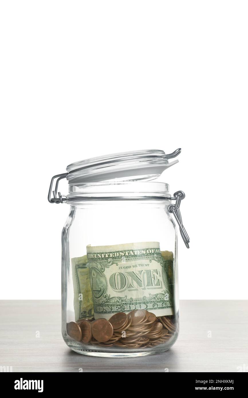 Tip jar with money on wooden table against white background Stock Photo ...