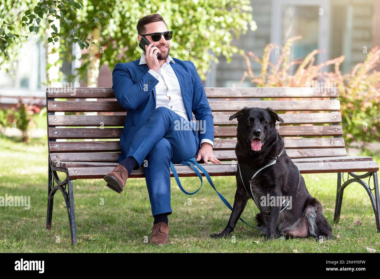 Handsome businessman in business suit is talking on his cell phone with ...