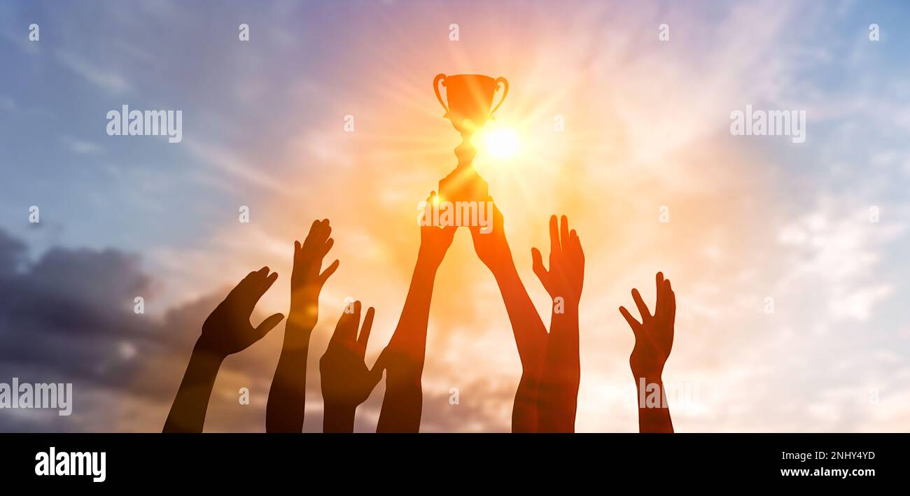 Success of teamwork, joint achievement of goal in business and life. Winning team is holding ...