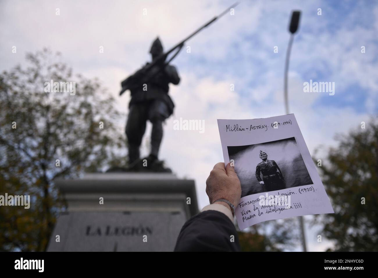 A man holds a poster with a photo of the founder of La Legion, Jose ...