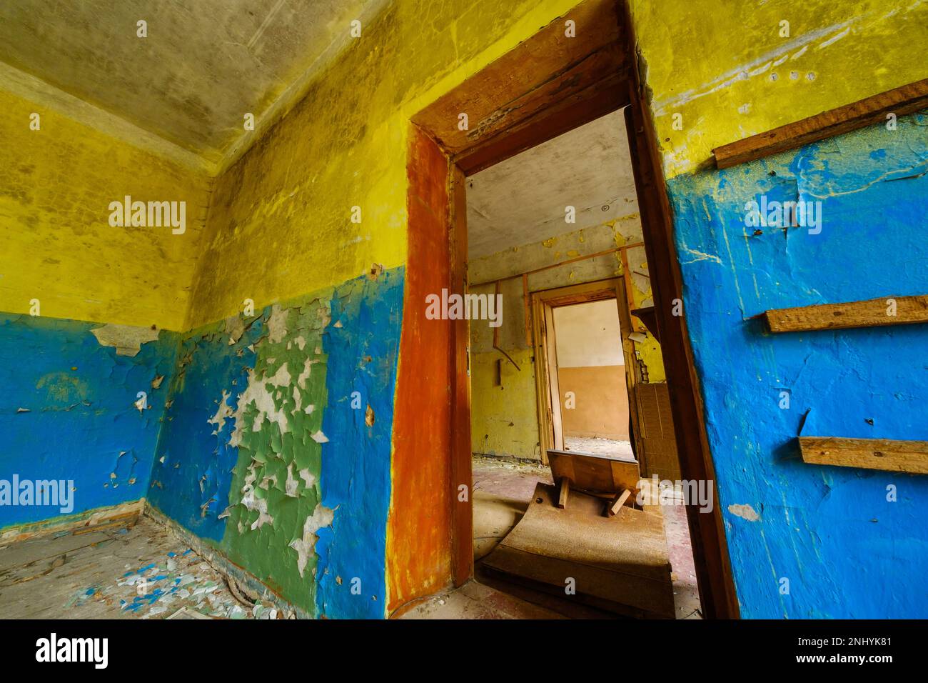 Bright painted flaky walls in yellow and blue inside of aged forgotten ...