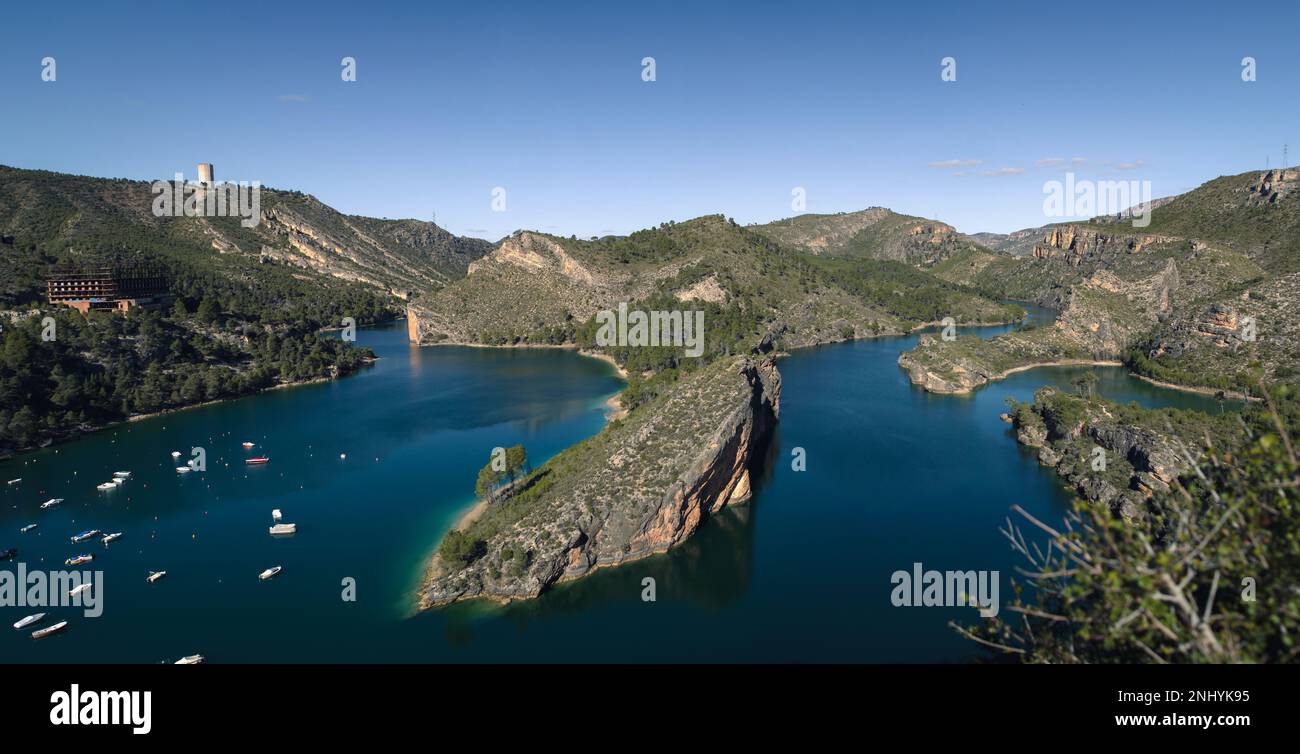 A scenic aerial view of the lake of Bolarque surrounded by lush green ...