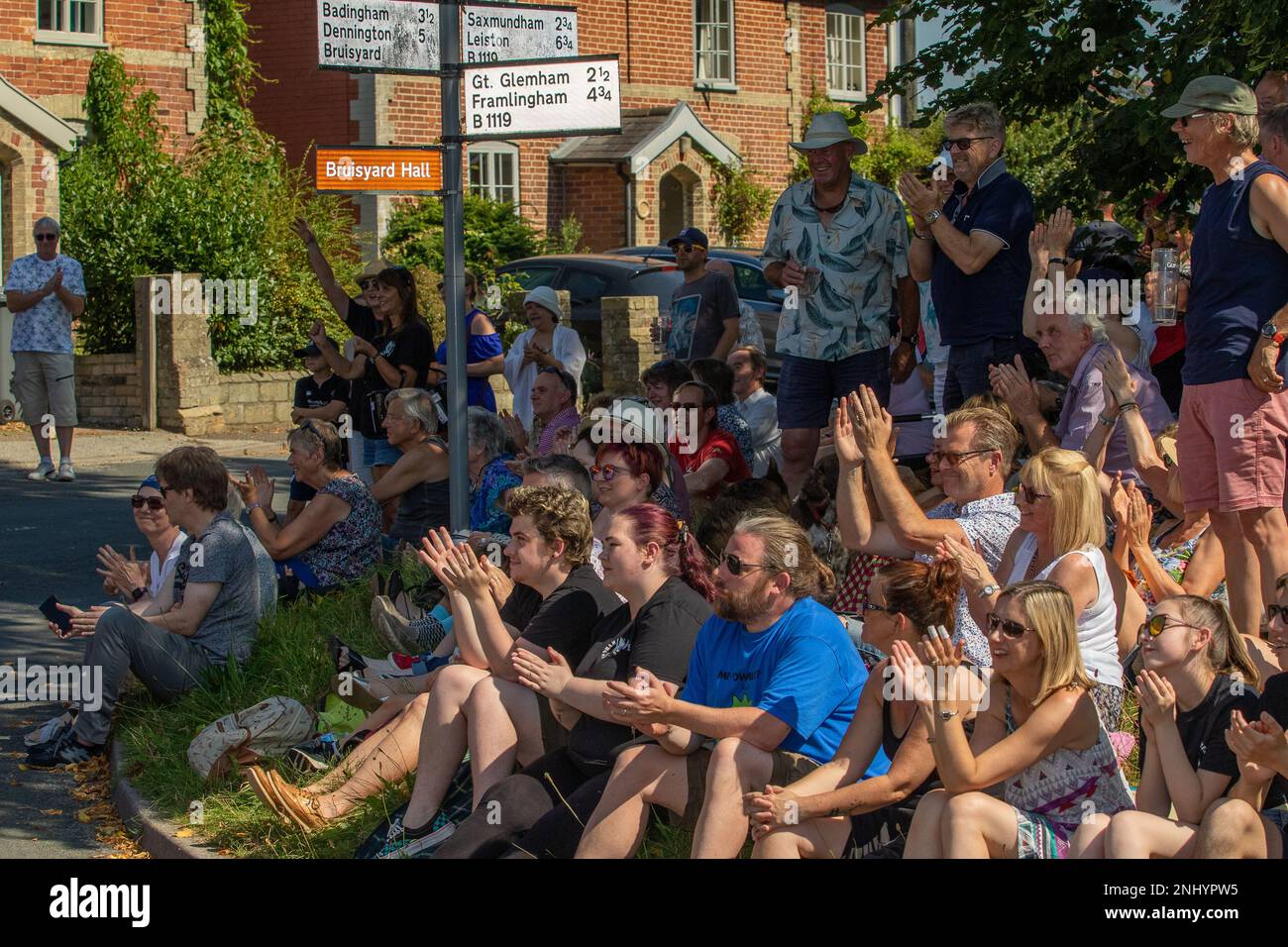 On a sunny Sunday villagers sit on the grass verge to watch the Rendham ...