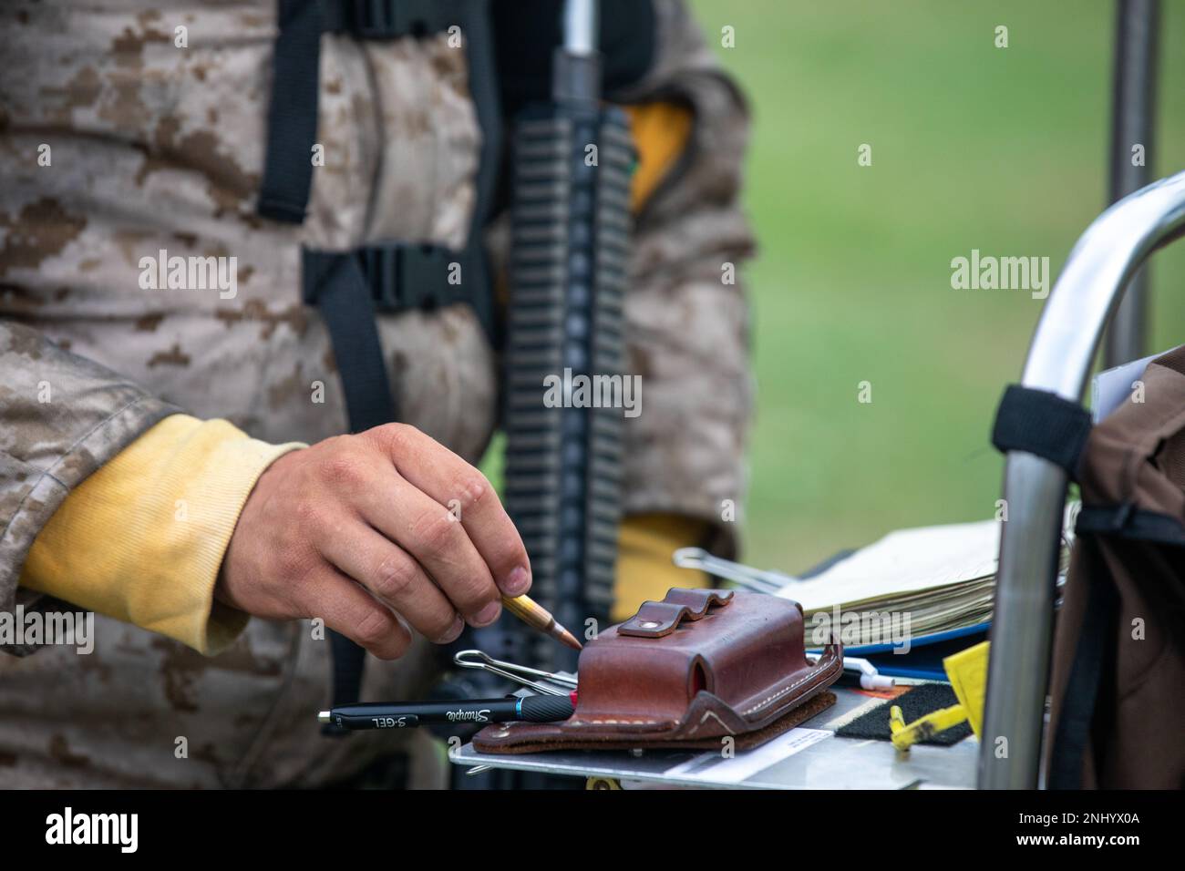 A Marine with the Marine Corps Shooting Team picks up ammunition during ...
