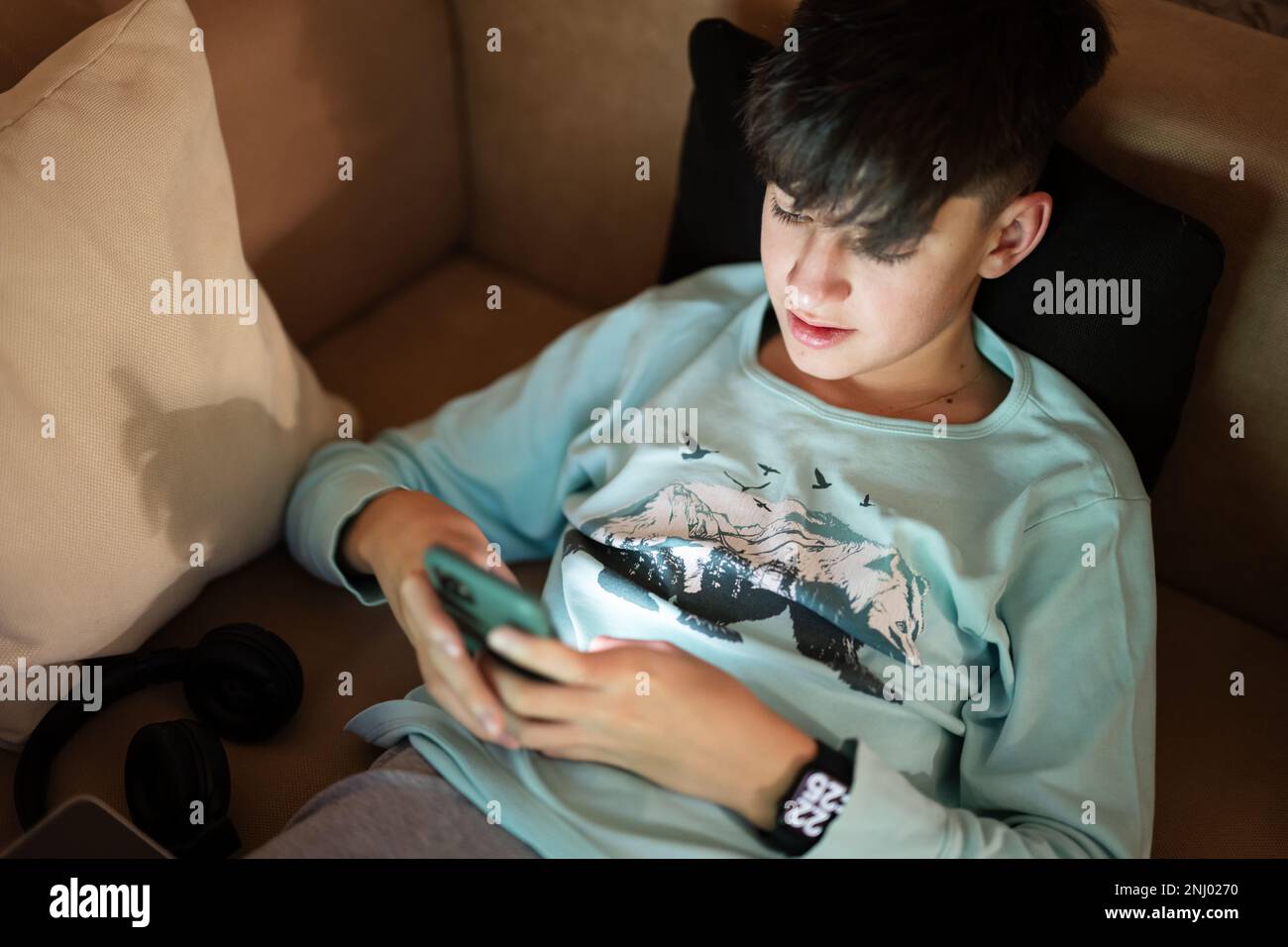 Teenage boy texting in bed hi-res stock photography and images - Alamy