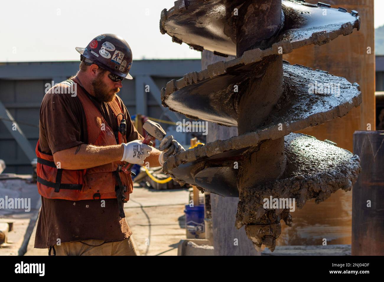 Derick Weimer, a contractor, hammers a drill to change out the teeth at ...