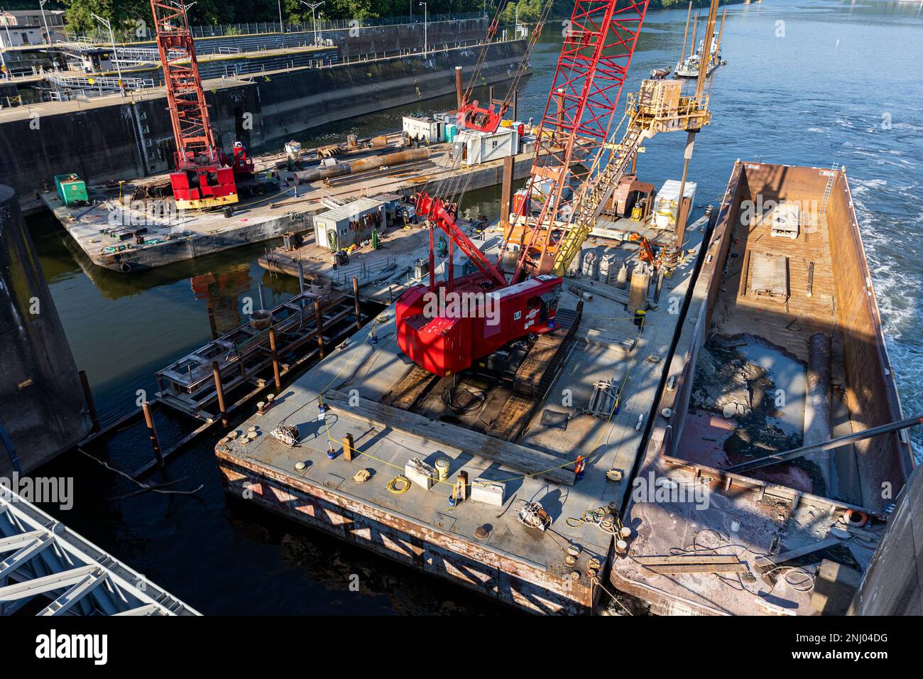 A crane operator uses a crane-mounted drill to burrow holes into the ...