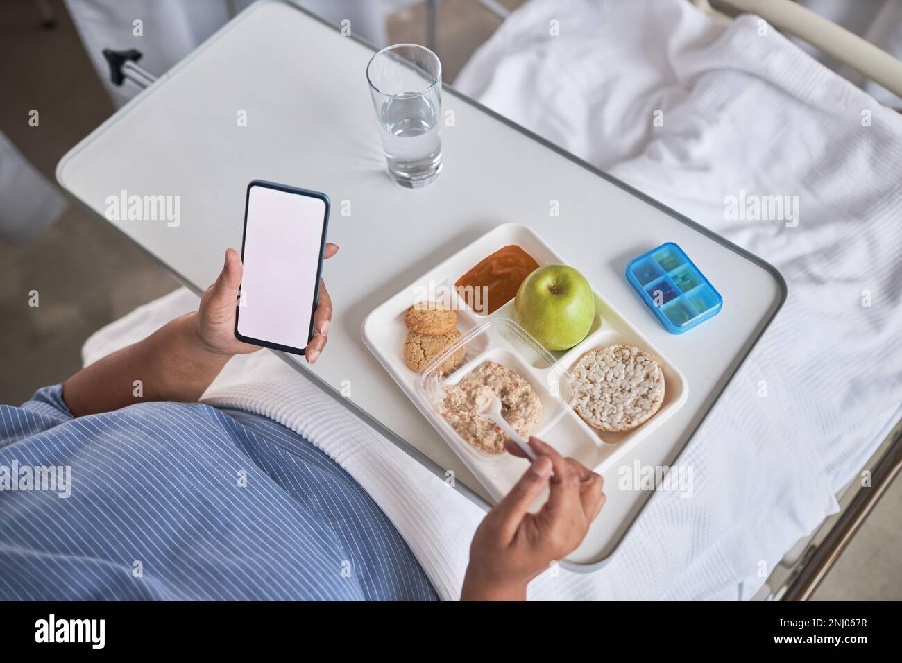 Top view of female patient eating hospital food dinner on tray, copy ...