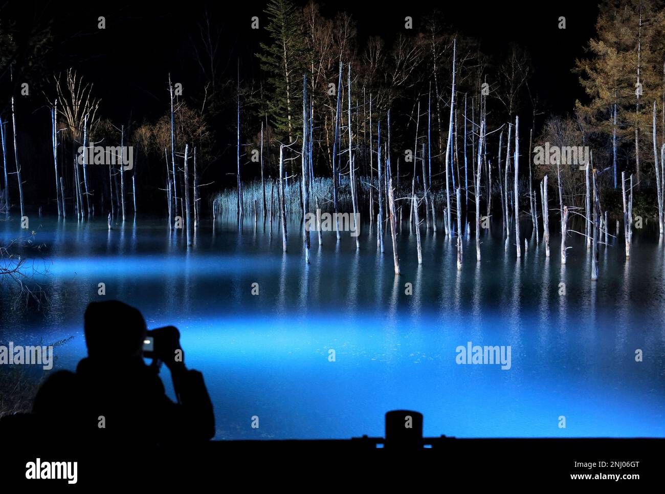 The Blue Pond, a popular tourist spot, is lit up with lights, giving ...
