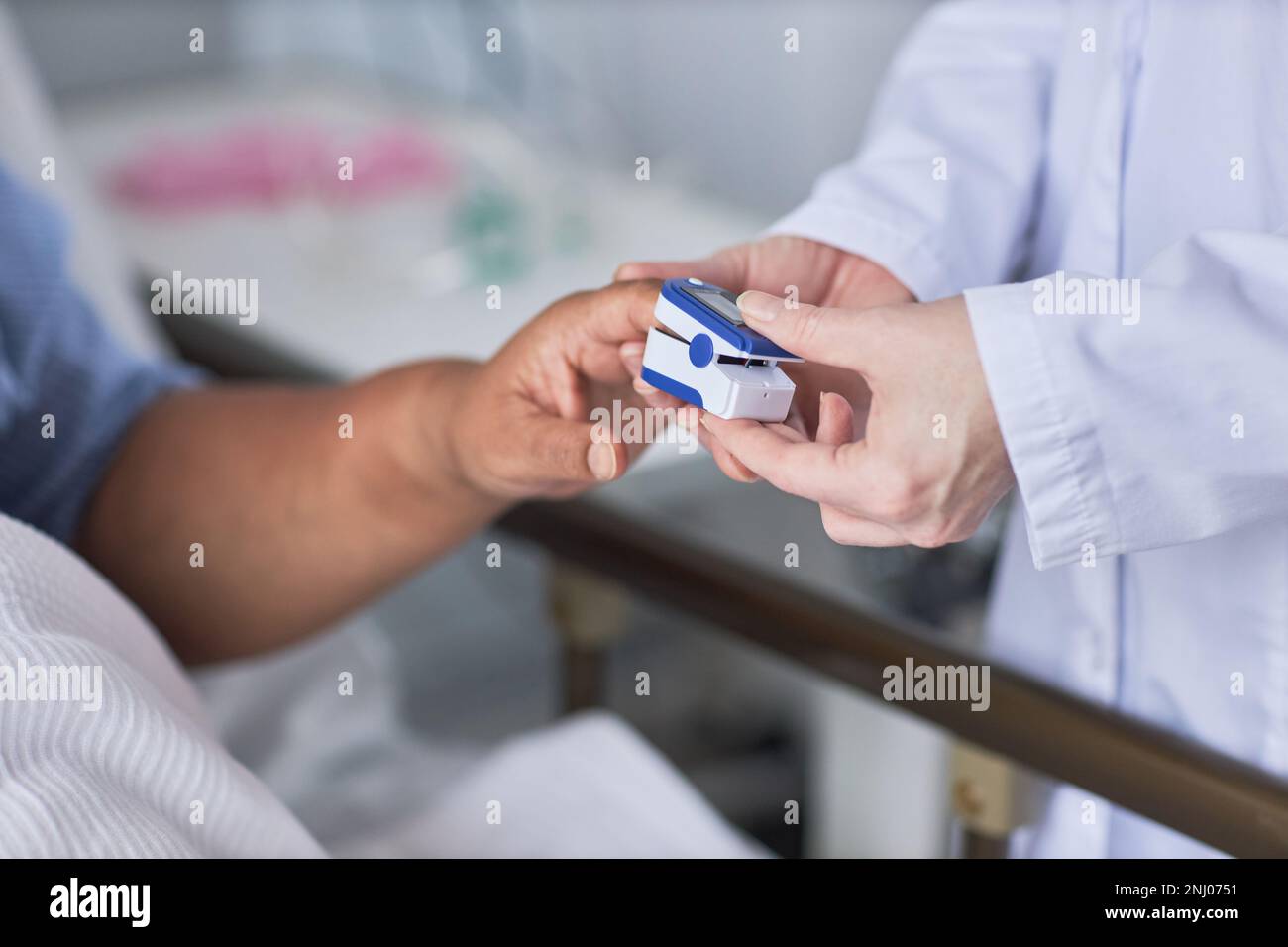 Minimal closeup of nurse measuring oxygen saturation of senior female ...