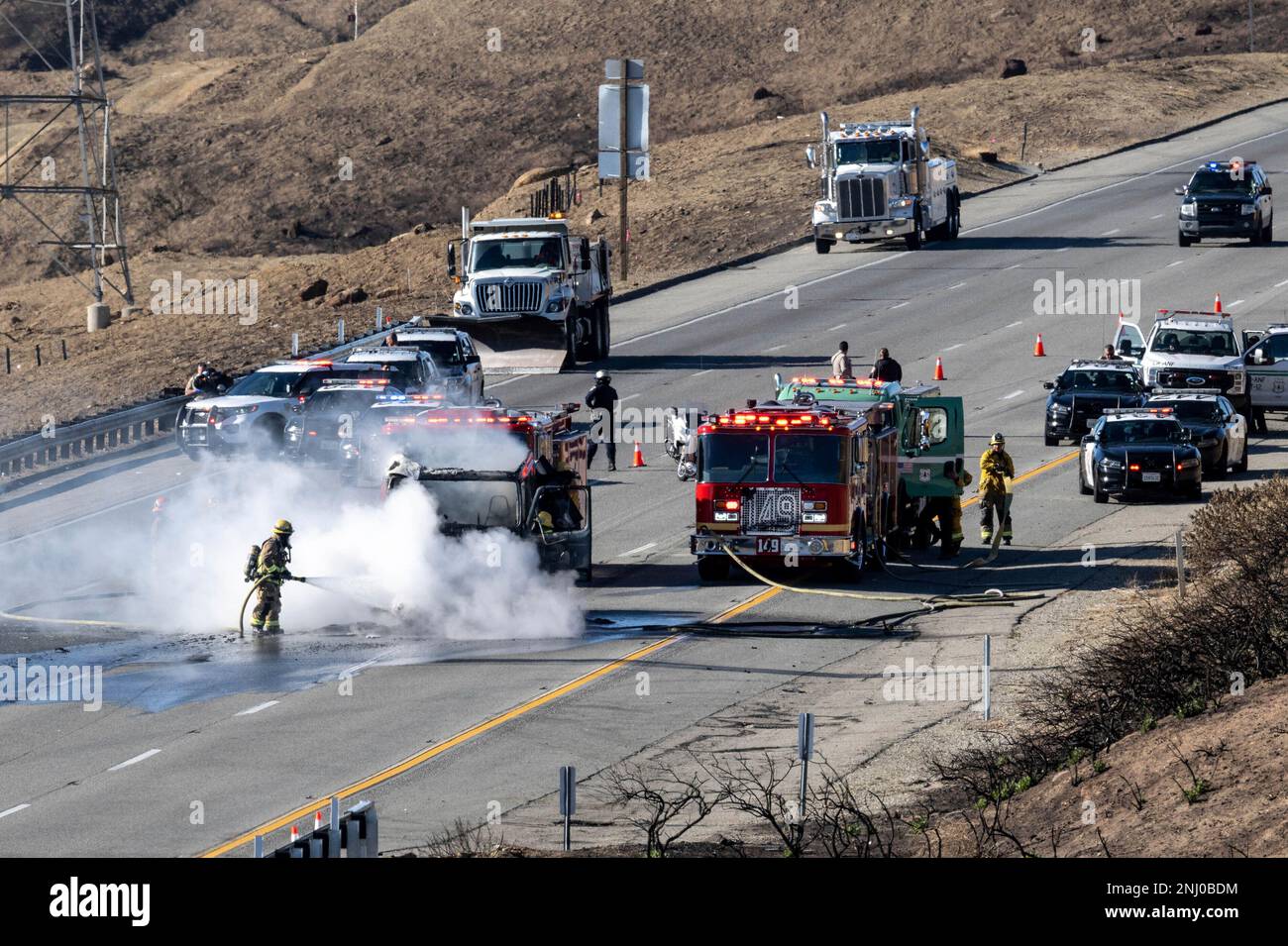 Firefighters put out a burning truck cab that caught fire after a low ...