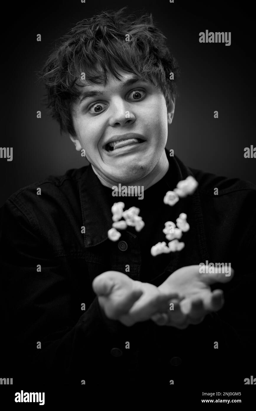 portrait of crazy young man throwing up popcorn Stock Photo - Alamy