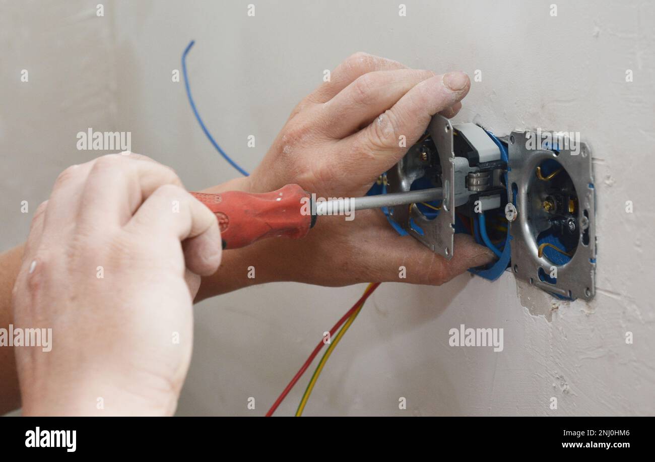 Electrican installing sockets, outlet plugs in the house Stock Photo ...
