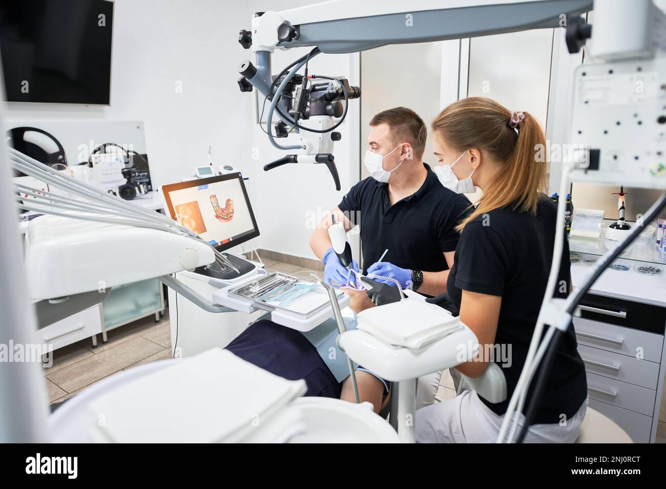 Dentist scanning patient's teeth with modern machine for intraoral ...