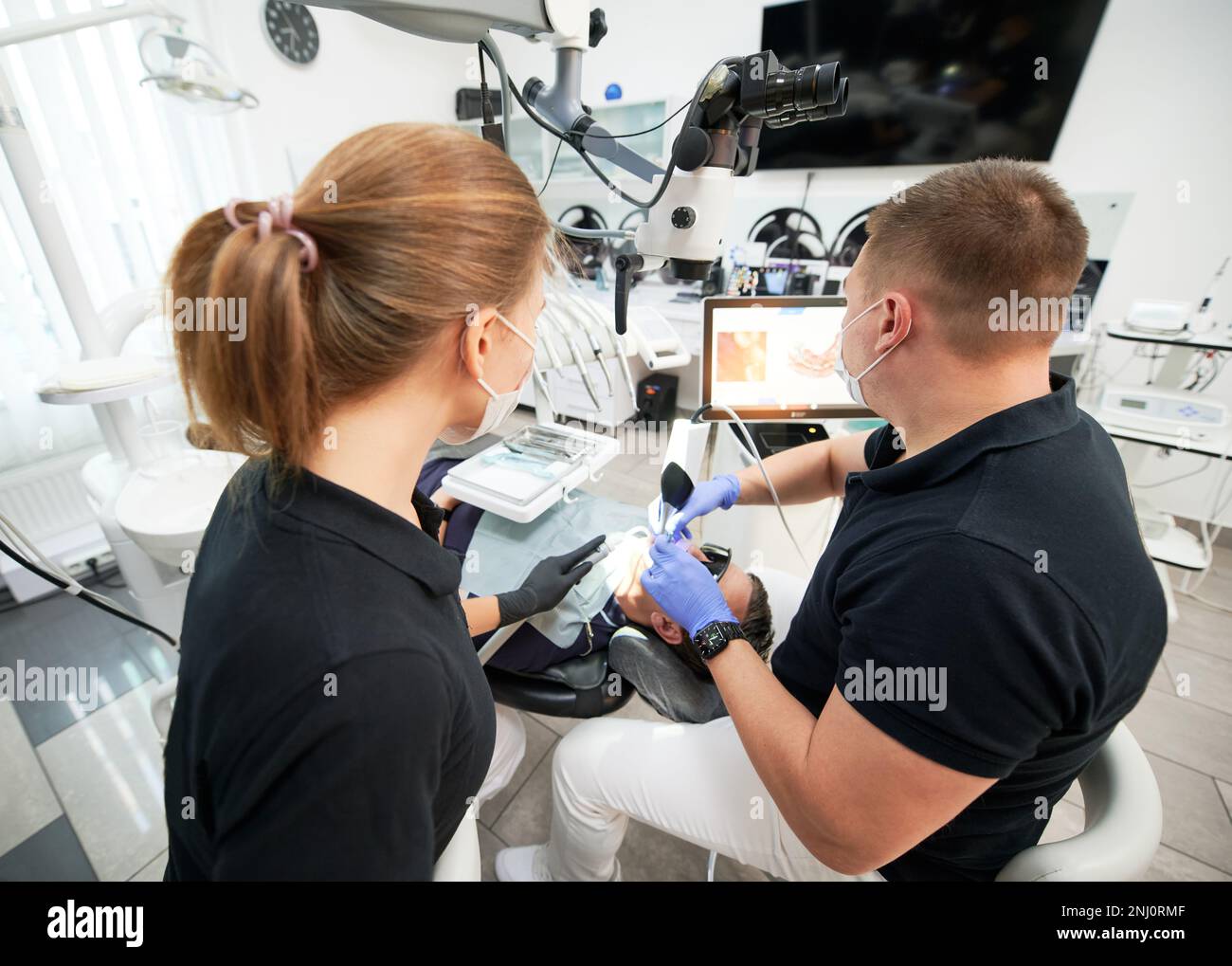Dentist scanning patient's teeth with modern machine for intraoral ...