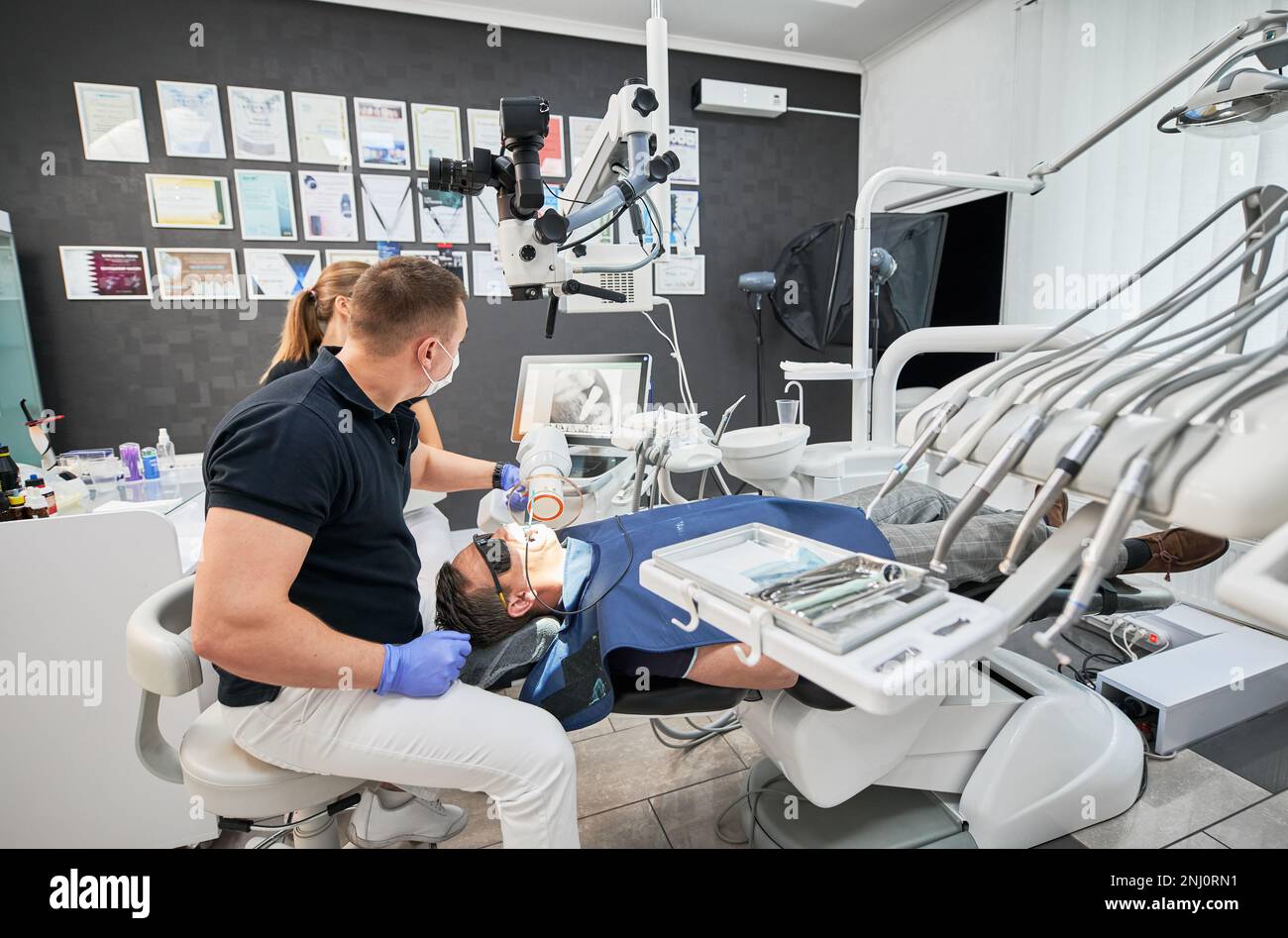 Dentist making X-ray, examining, inspecting problem, disease, holding ...