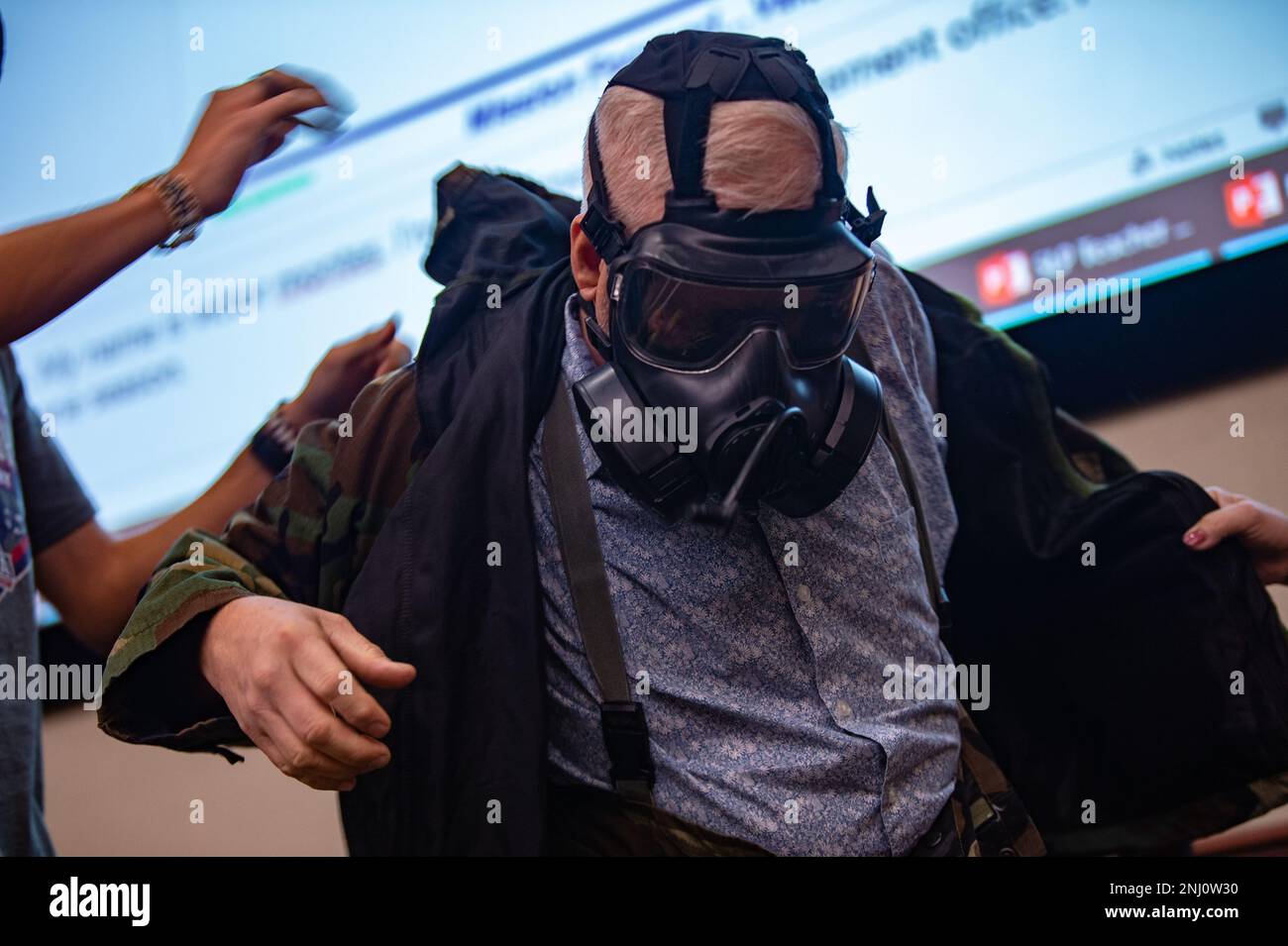 A teacher puts on mission oriented protective posture (MOPP) gear ...