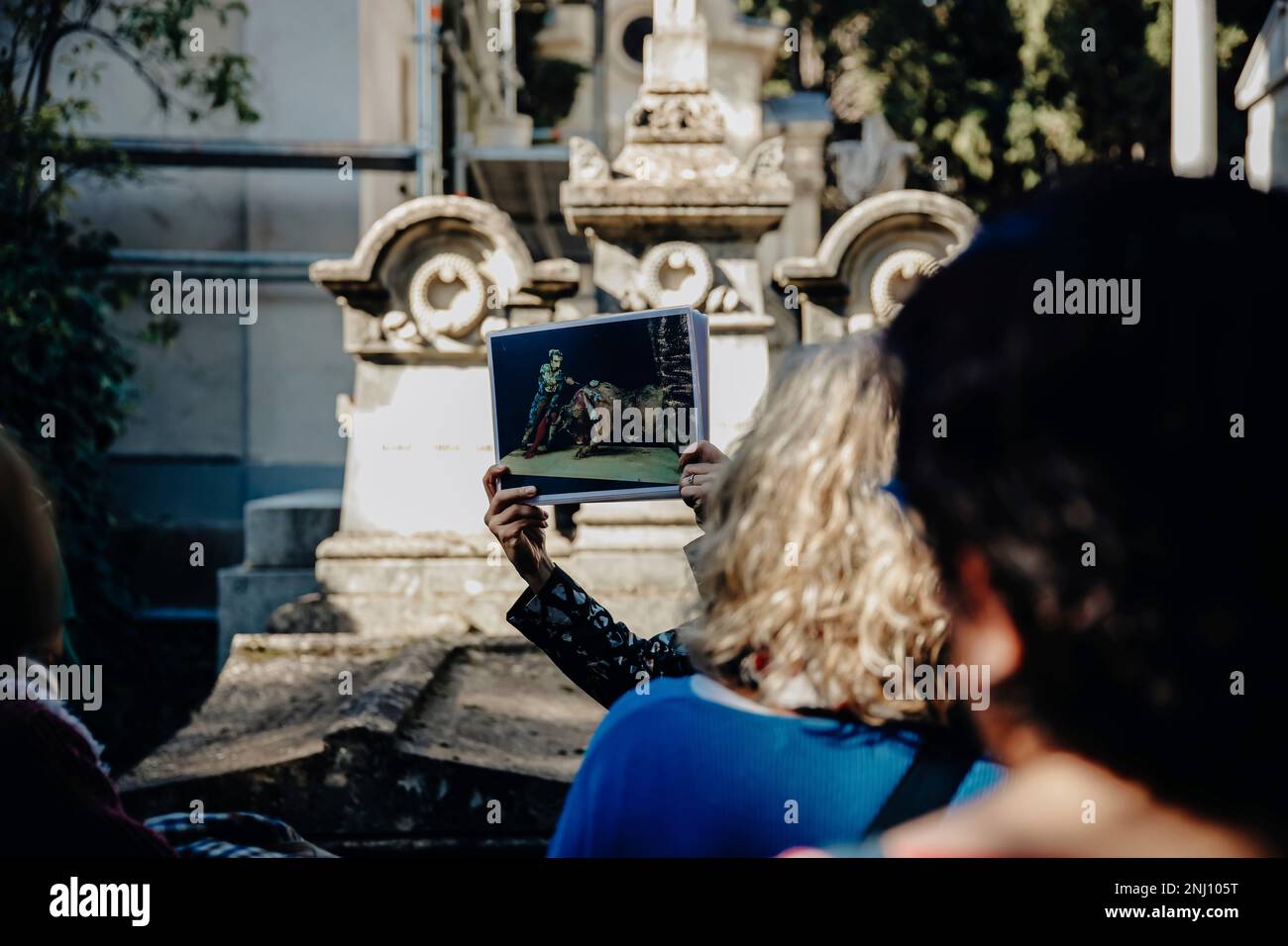 A guide shows a photo during a visit to the Sacramental Cemetery of San ...