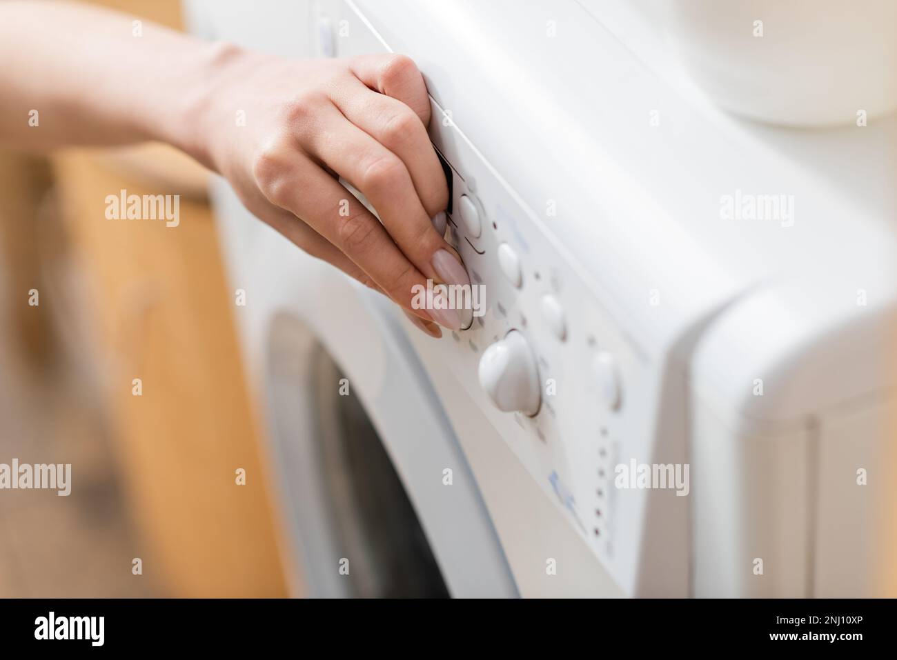 Cropped view of woman pushing button of washing machine at home,stock ...