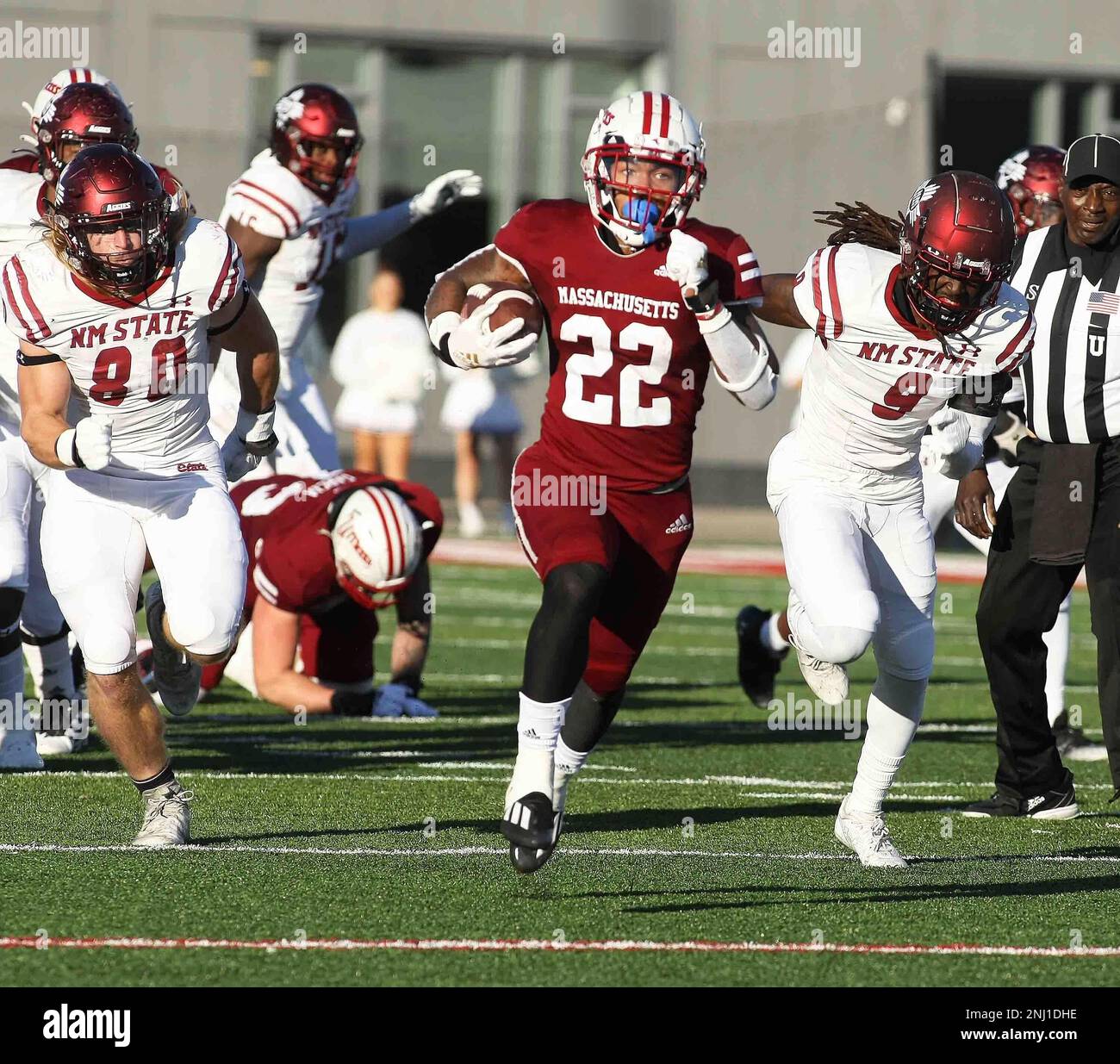 Massachusetts' Kay'Ron Adams (22) powers the ball up the field past New ...