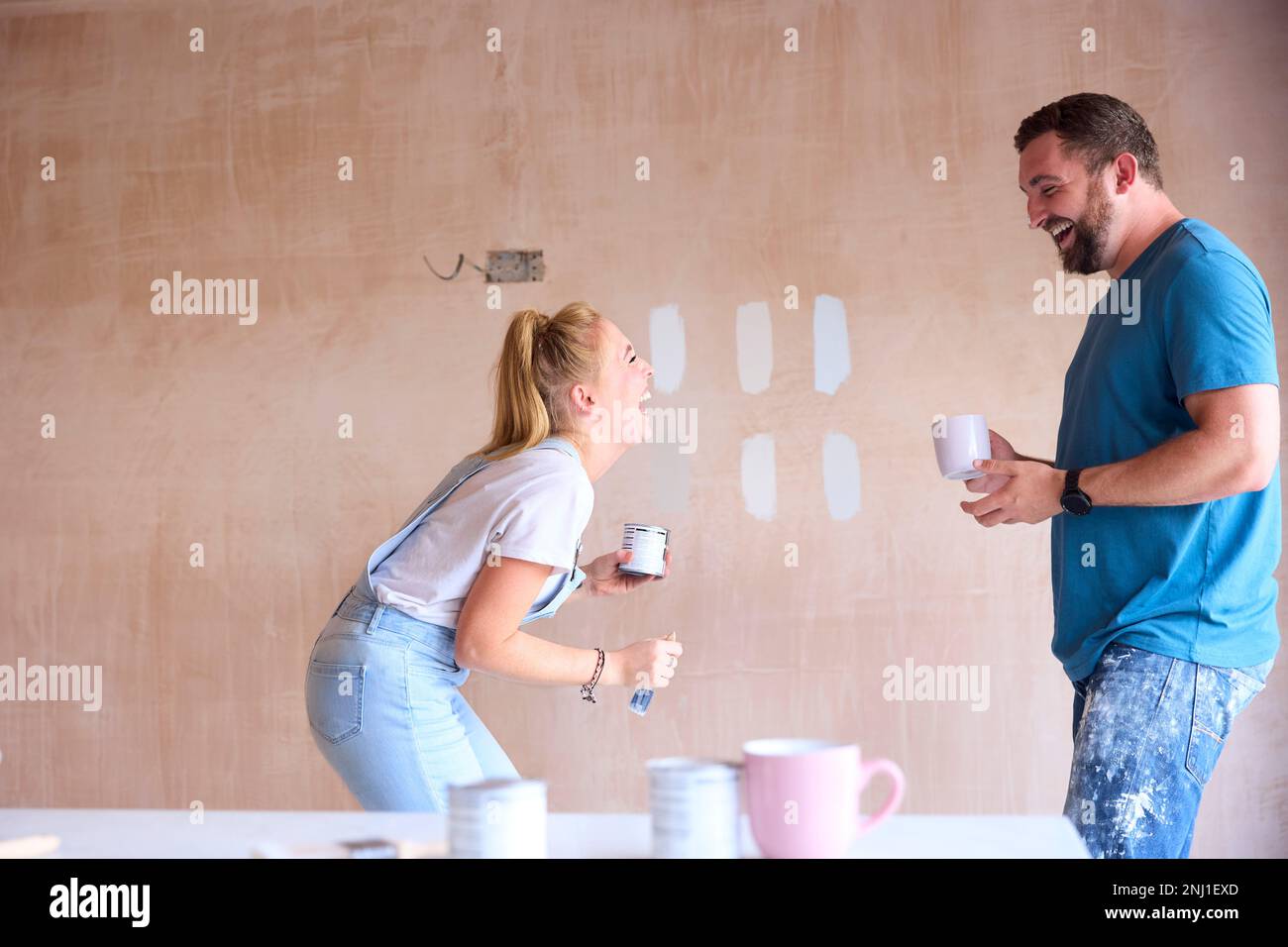 Laughing Couple Renovating Kitchen At Home Painting Tester Paint Colour ...