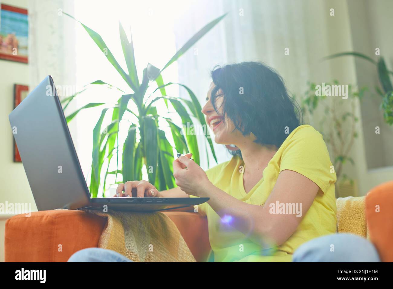 Positive woman watching video on laptop and laughing from joke, very ...